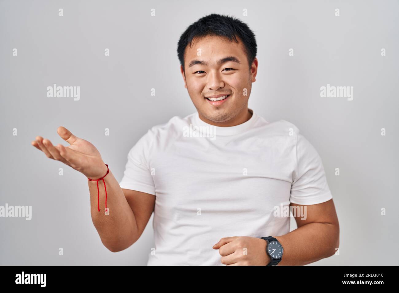 Young chinese man standing over white background smiling cheerful ...
