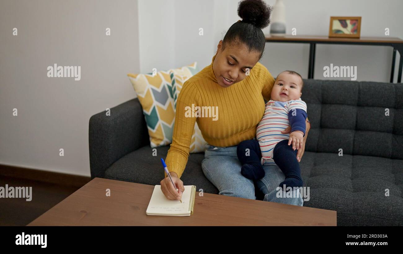 Mother and son sitting on sofa writing notes at home Stock Photo - Alamy