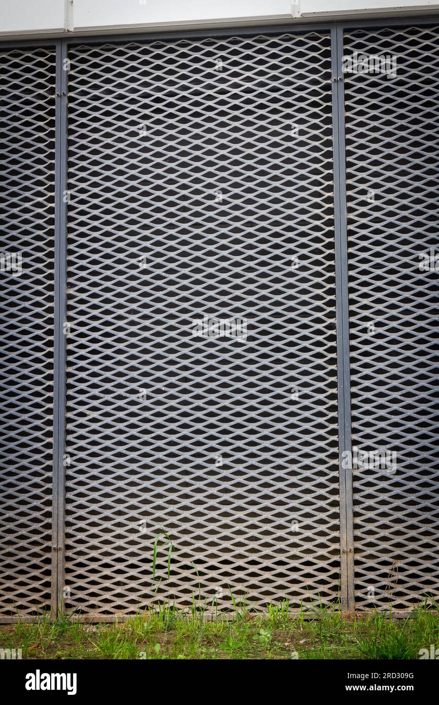 Iron grid wall and green grass. Architecture detail background Stock ...