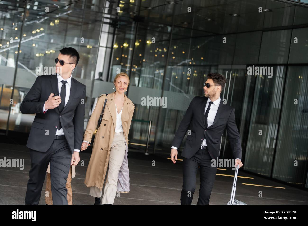 handsome bodyguards protecting privacy of female clients, happy woman and daughter walking out ...
