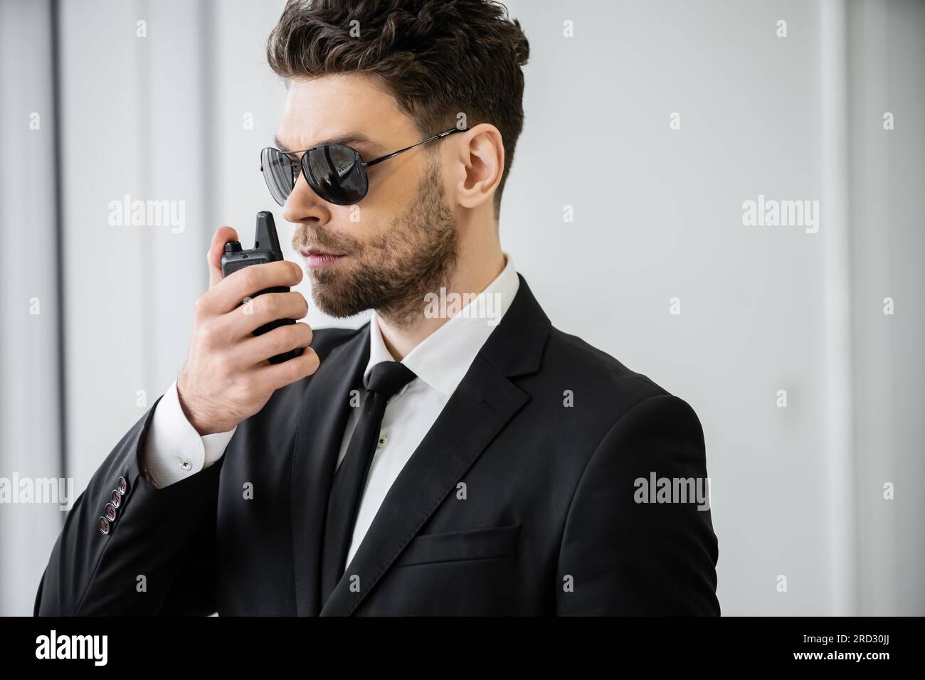 surveillance, handsome bodyguard communicating through walkie talkie ...