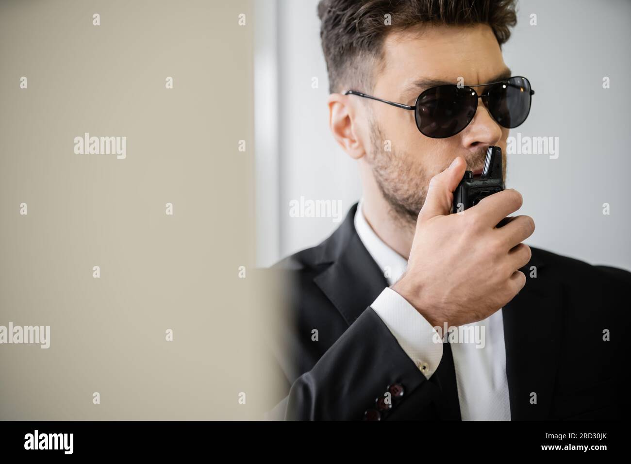 surveillance, bodyguard communicating through walkie talkie, man in ...