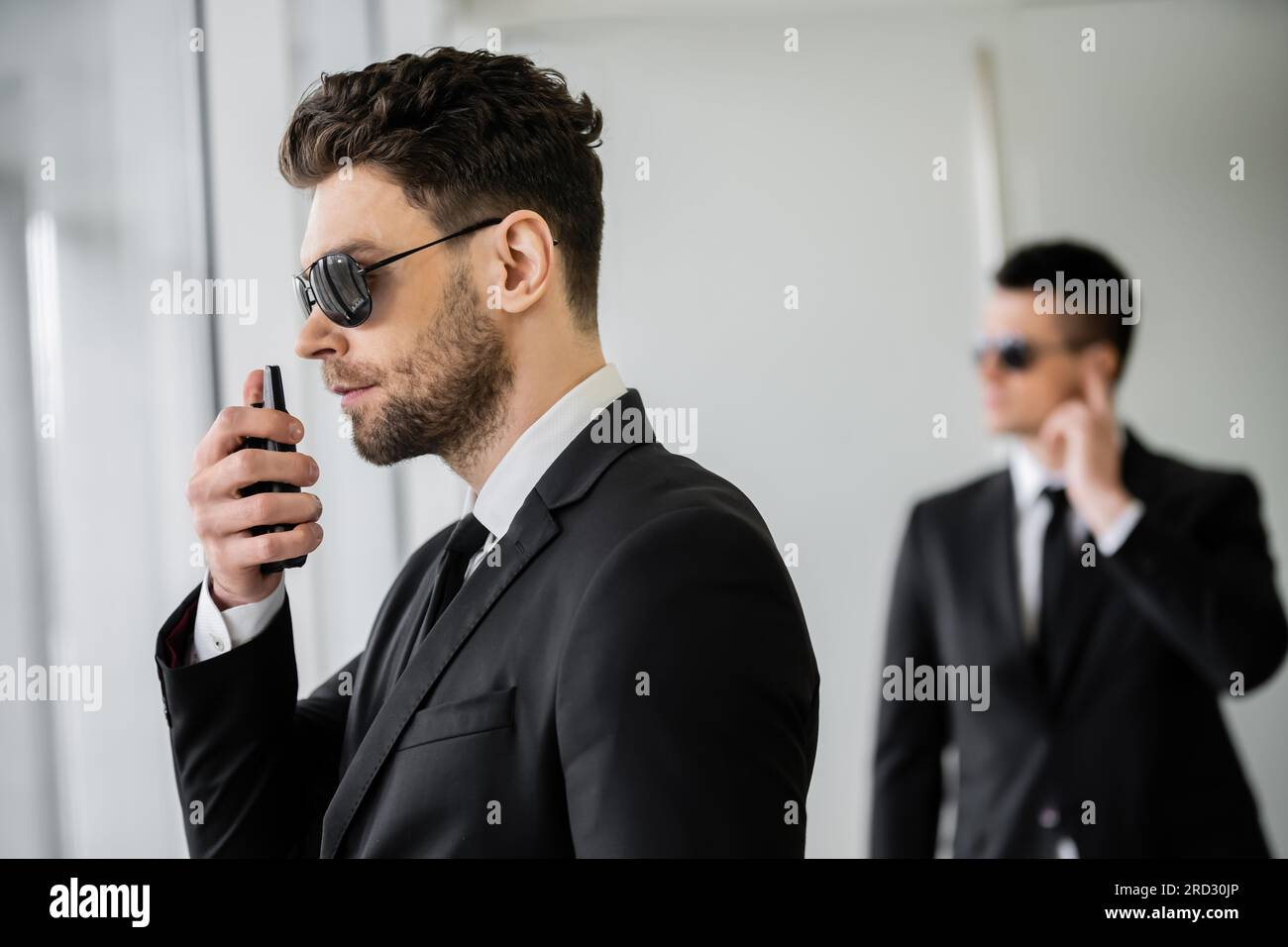 surveillance, bodyguard communicating through walkie talkie, man in ...