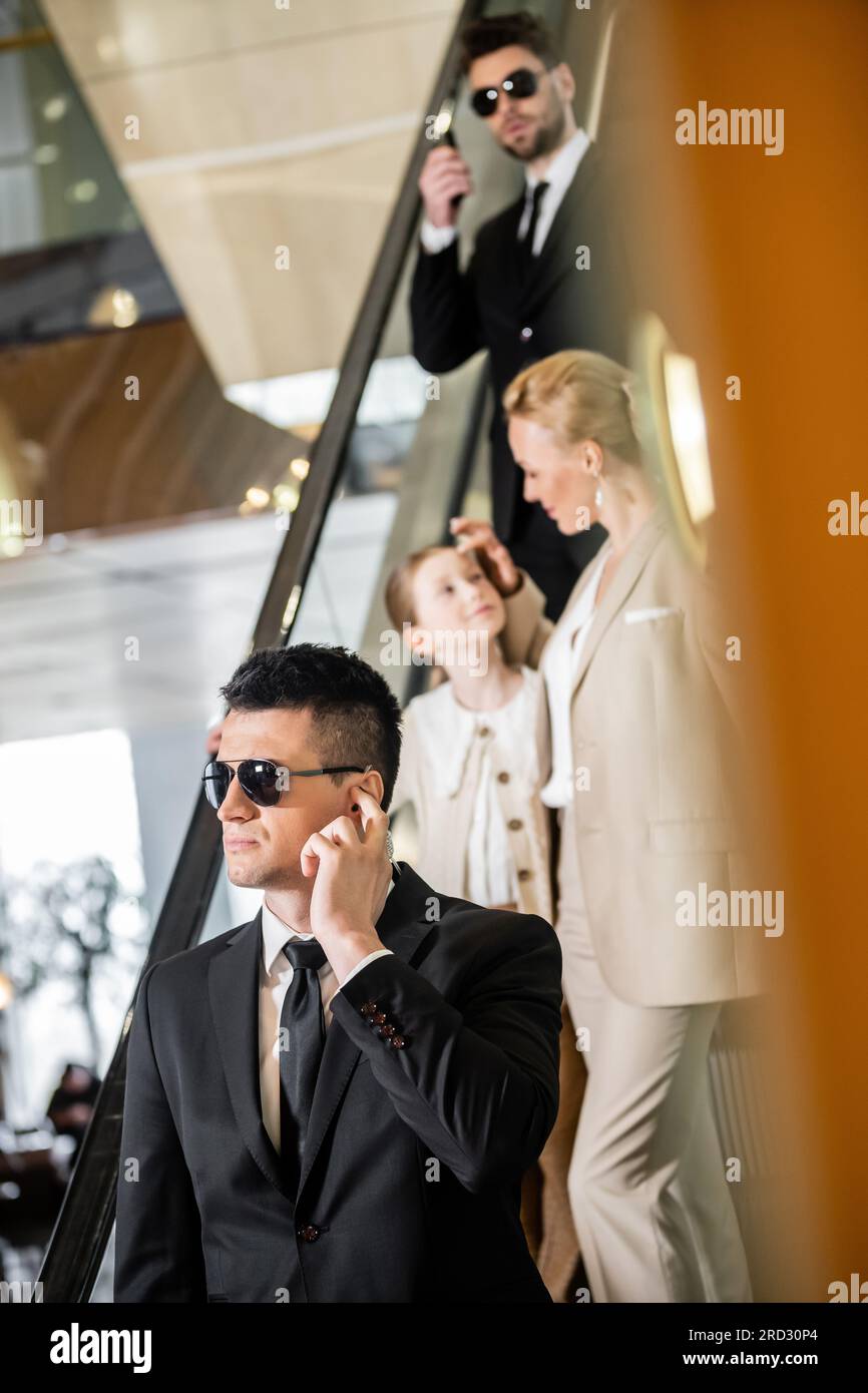 personal security concept, bodyguards communicating while protecting ...