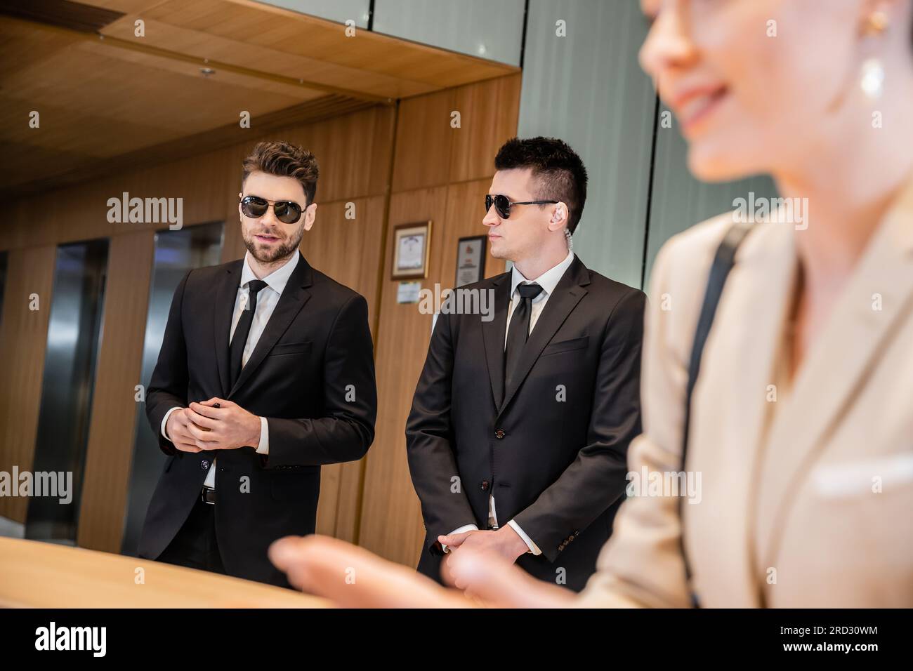 handsome bodyguards protecting successful client in hotel, woman on ...