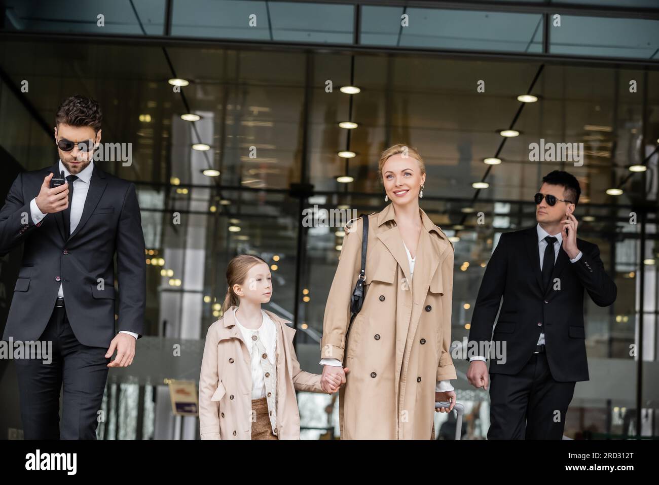 bodyguards walking next to cheerful woman and preteen kid, entering ...