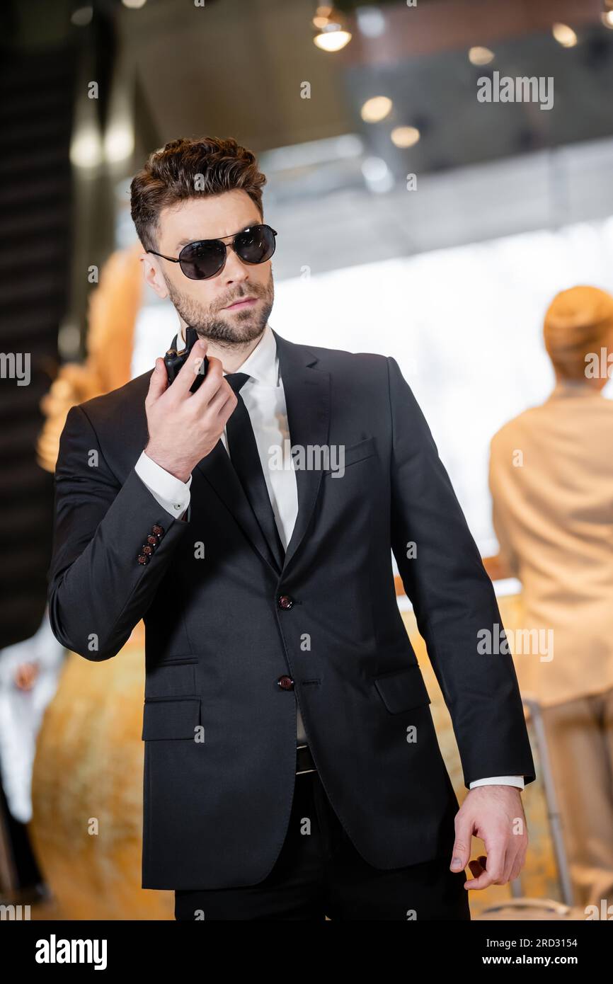 bodyguard concept, handsome man in formal wear and tie holding walkie ...