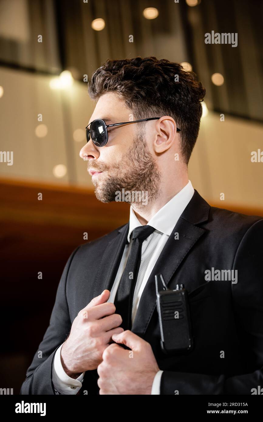 good looking bodyguard, security worker in suit and sunglasses standing ...