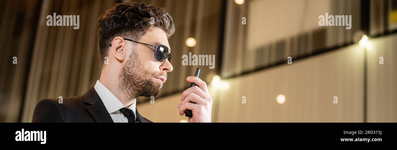 good looking bodyguard, security worker in suit and sunglasses working ...