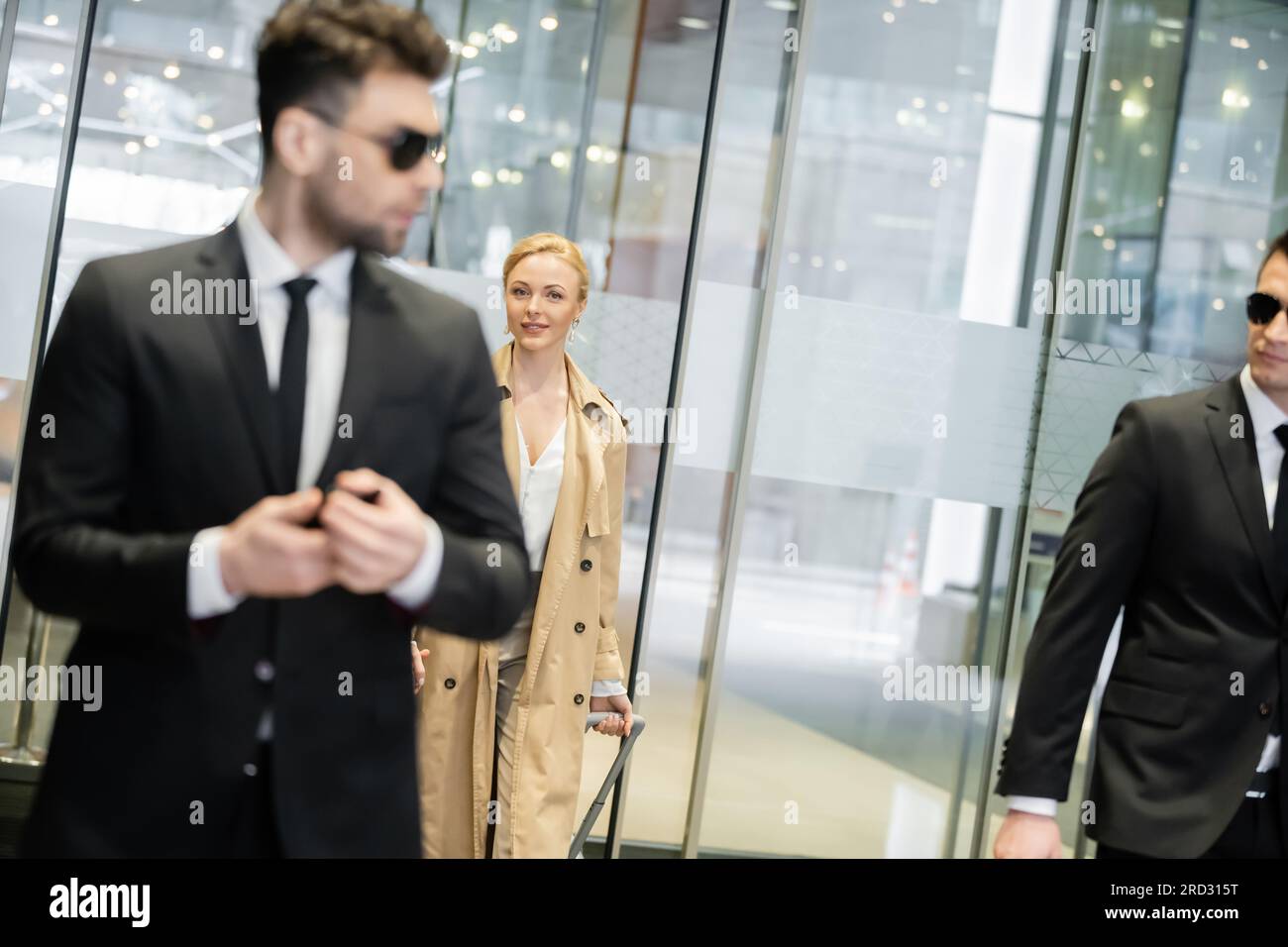 private security, blonde woman in trench coat entering into hotel ...