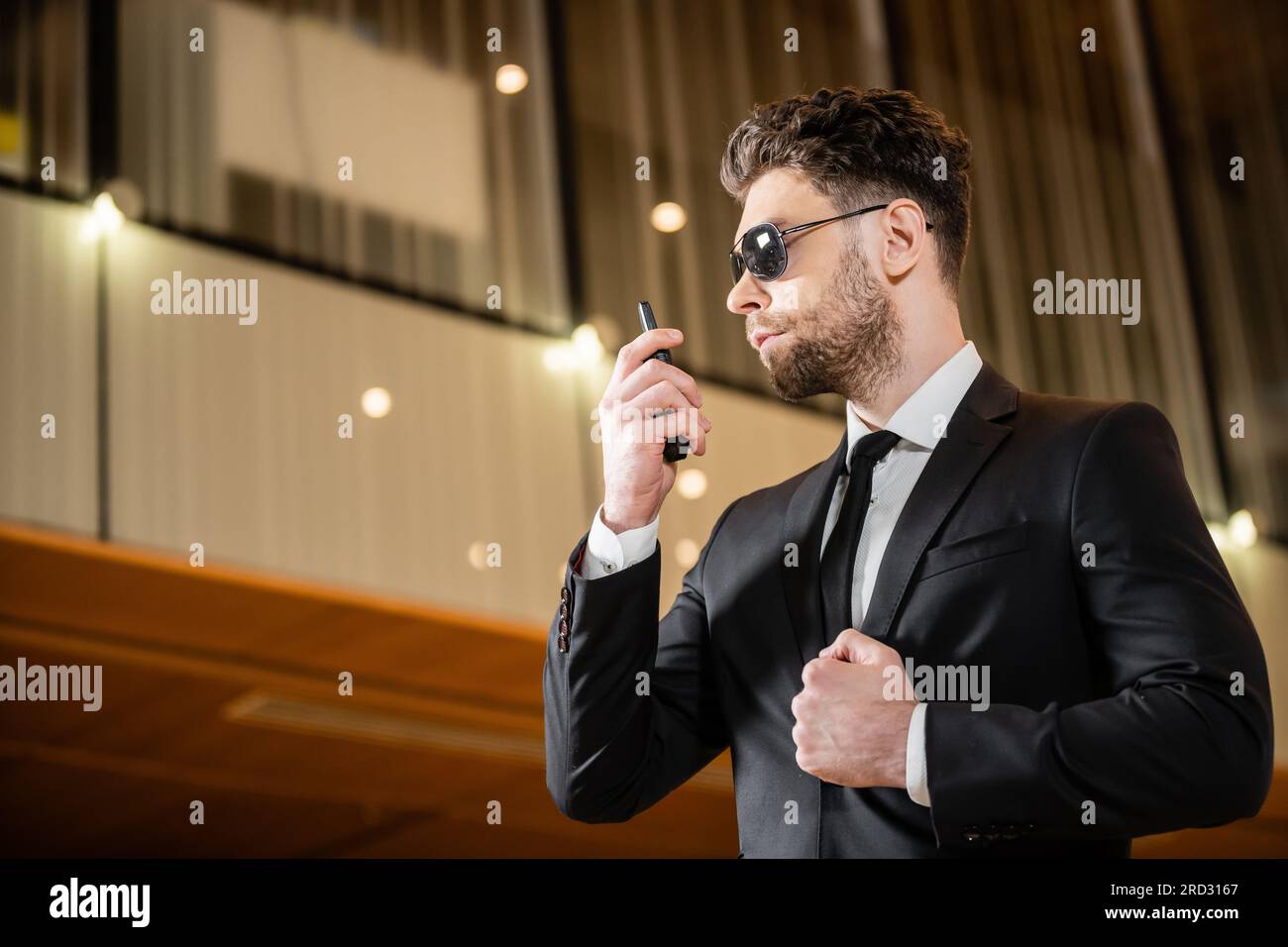 good looking bodyguard, security worker in suit and sunglasses working ...