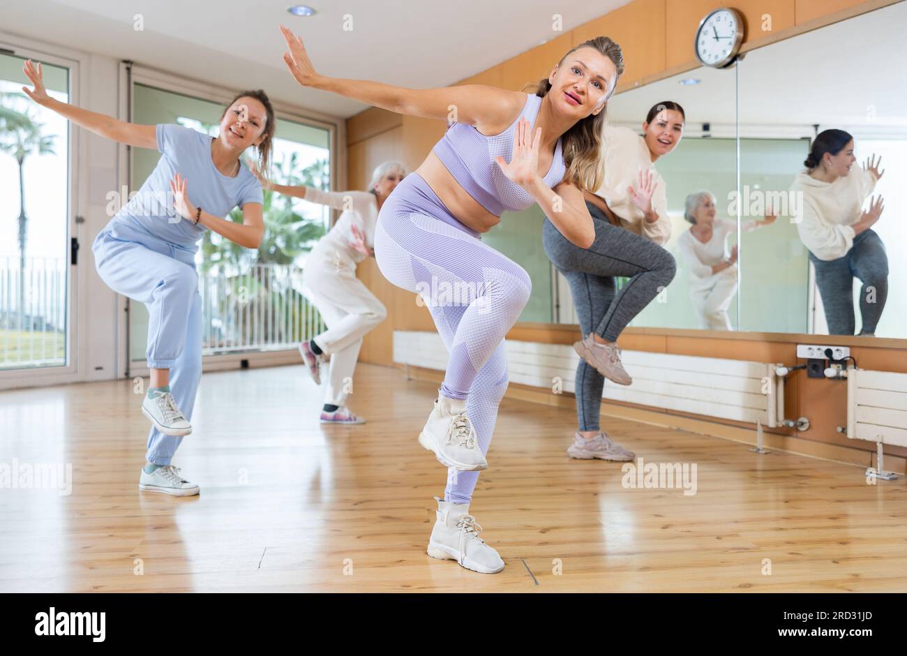 Females doing dance workout during group classes in fitness center ...