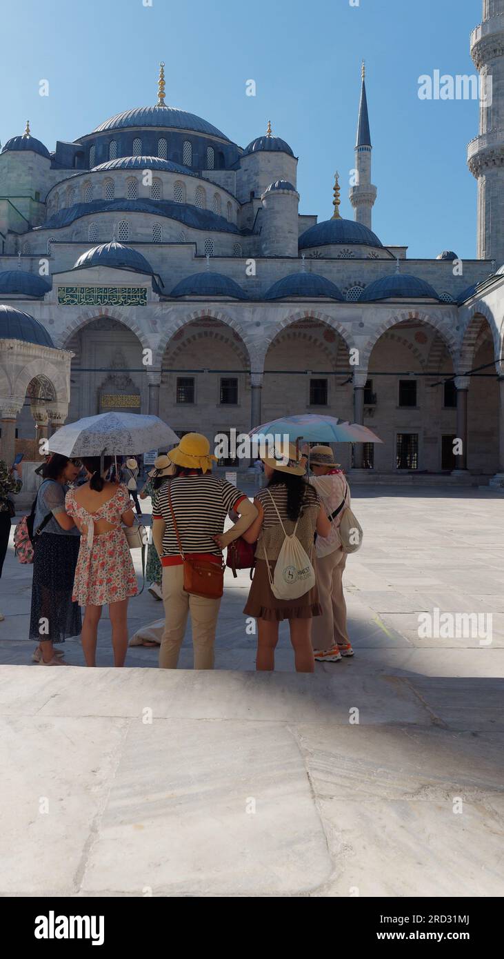 Visitors shelter from the sun using umbrellas in the Sahn aka Courtyard ...