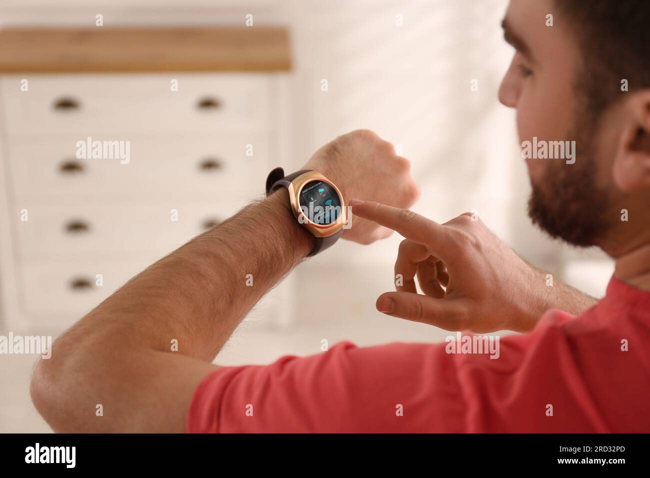 Man setting smart home control system via smartwatch indoors. App ...