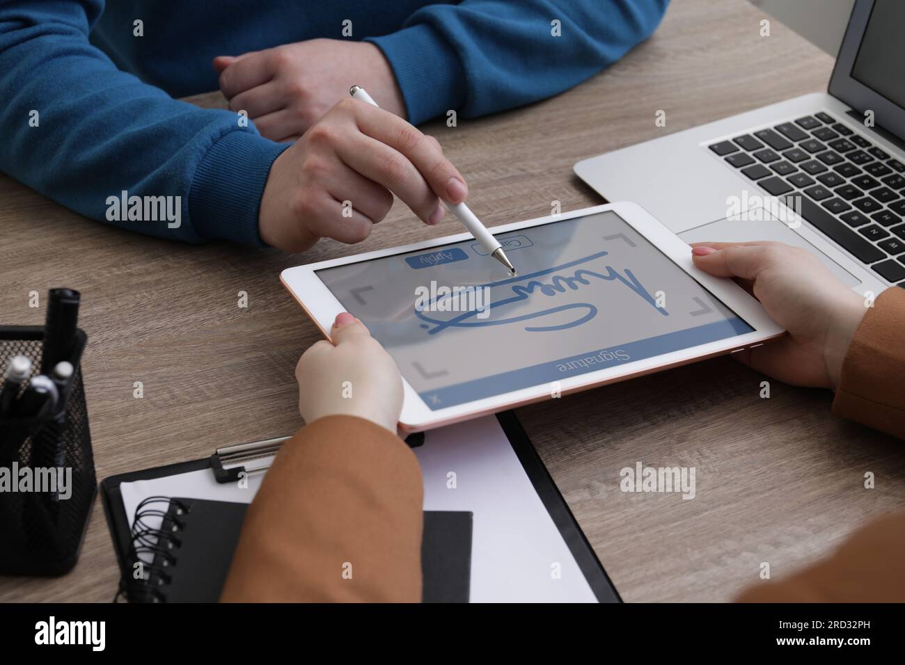 Electronic signature. Man using stylus and tablet at wooden table ...