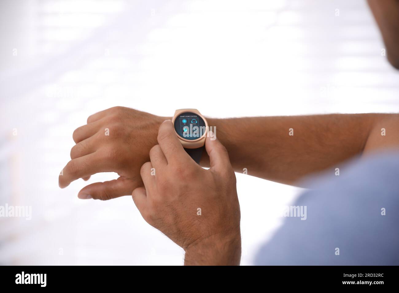 Man setting smart home control system via smartwatch against light ...