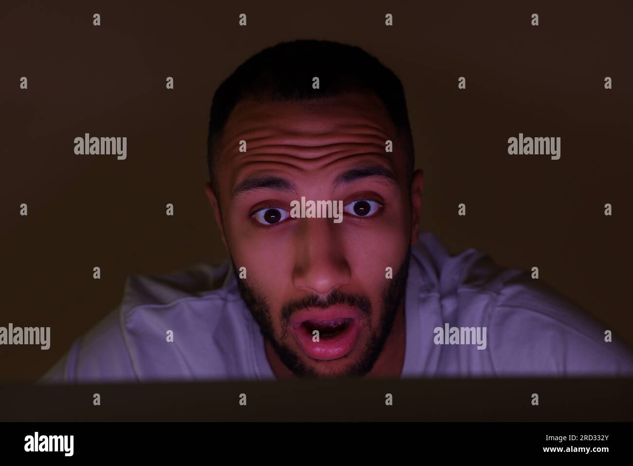 Shocked man using computer at night. Internet addiction Stock Photo - Alamy