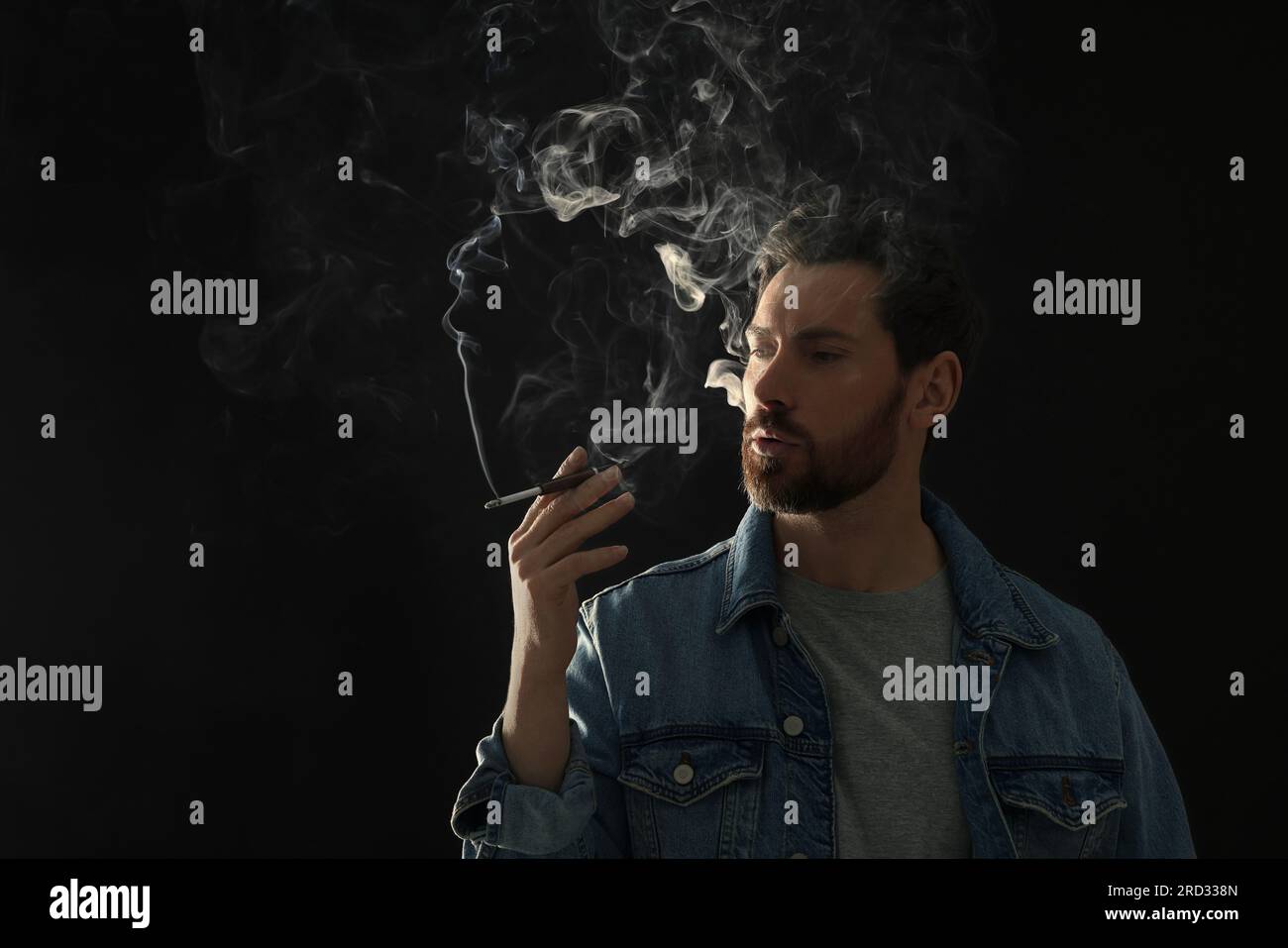 Man using cigarette holder for smoking on black background, space for ...