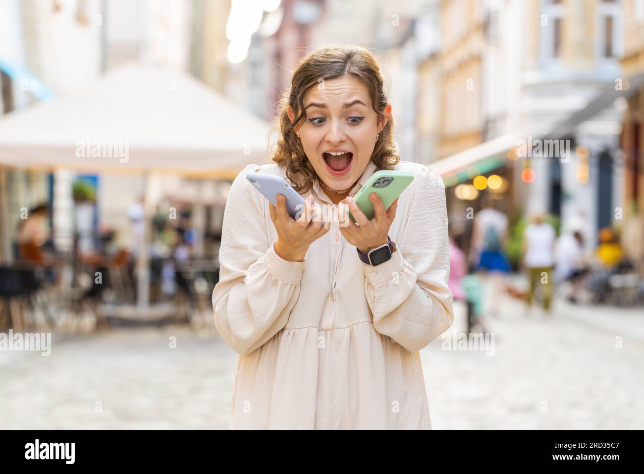 Irritated nervous stressed young woman talking screaming on two mobile ...