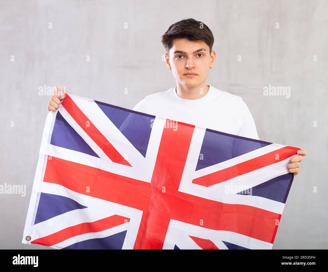 Focused young guy holding UK flag Stock Photo - Alamy