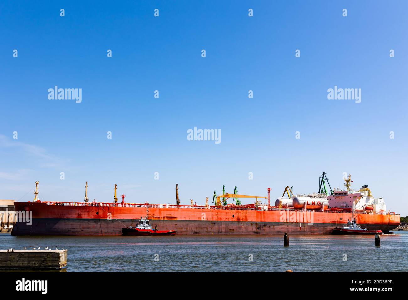LNG tanker maneuvering in the port. Use of tugs/pushers to turn the ...