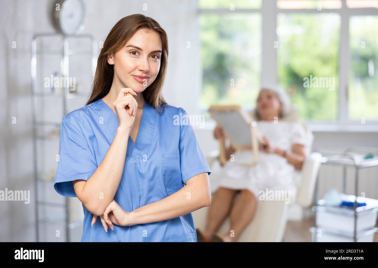 Female doctor cosmetologist stand with woman looking mirror behind in ...