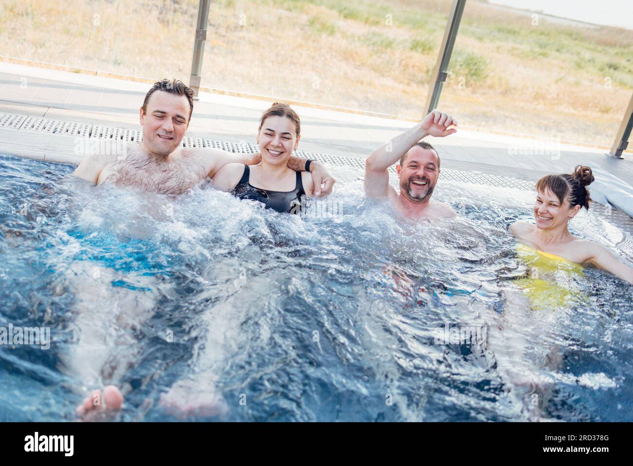Two married couples chat and take an outdoor pool. Friends laugh and ...