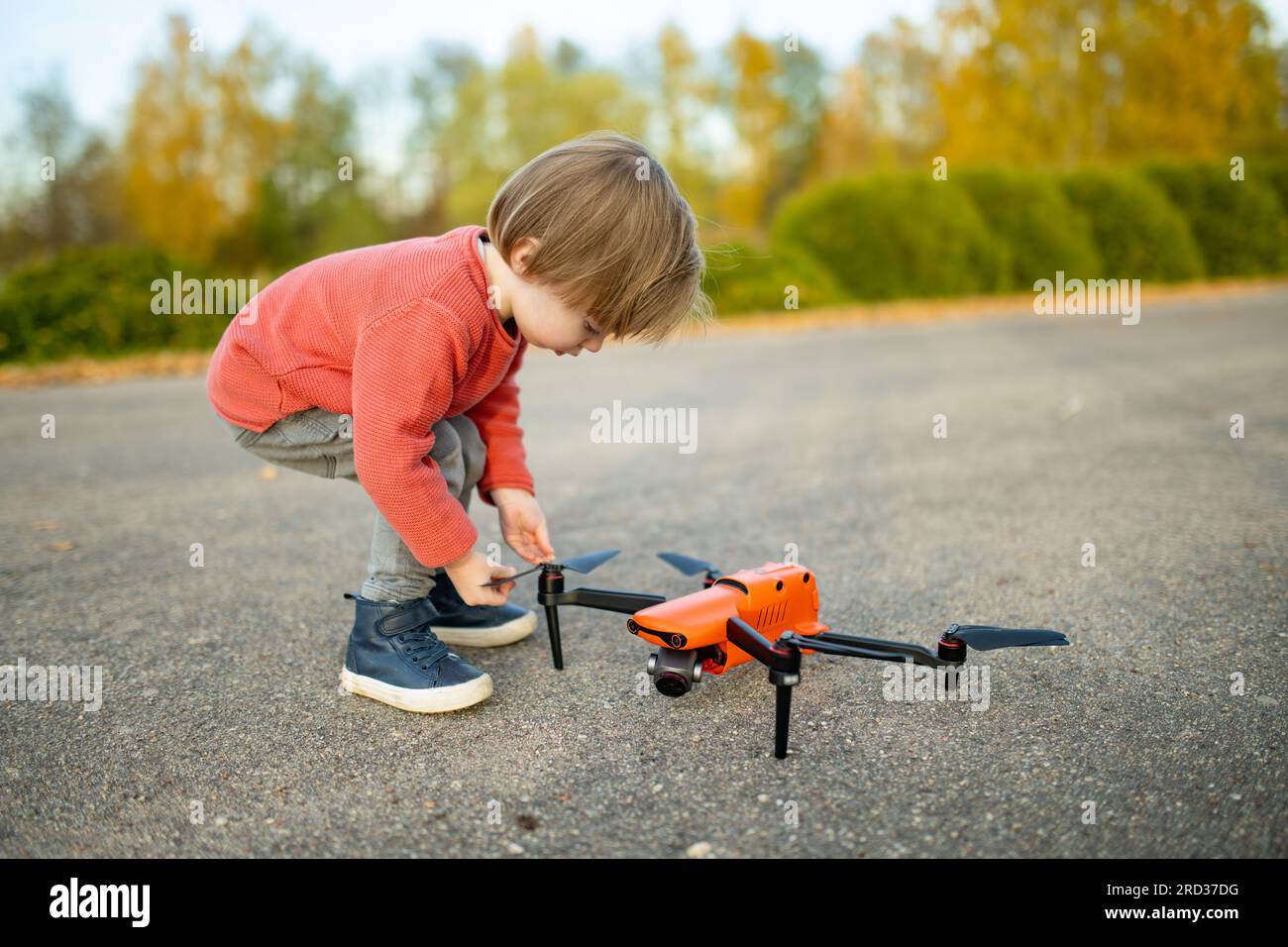 Cute toddler boy watching a drone. Cute toddler boy helping his father ...