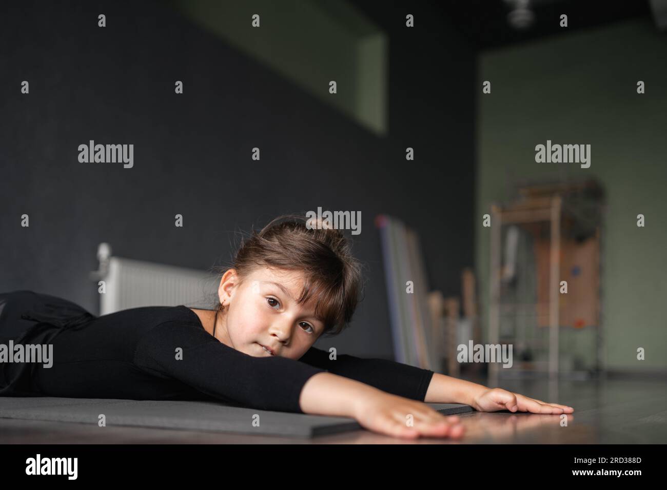Young 4 years old girl doing stretching exercises during her training ...