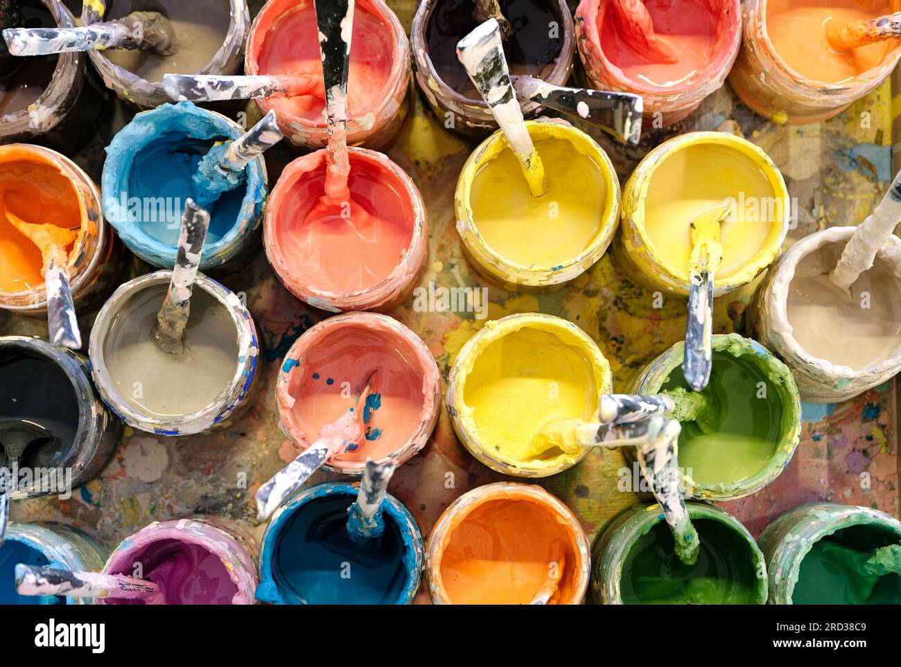 Large group of open old dirty cans of multi-colored paints, view from ...