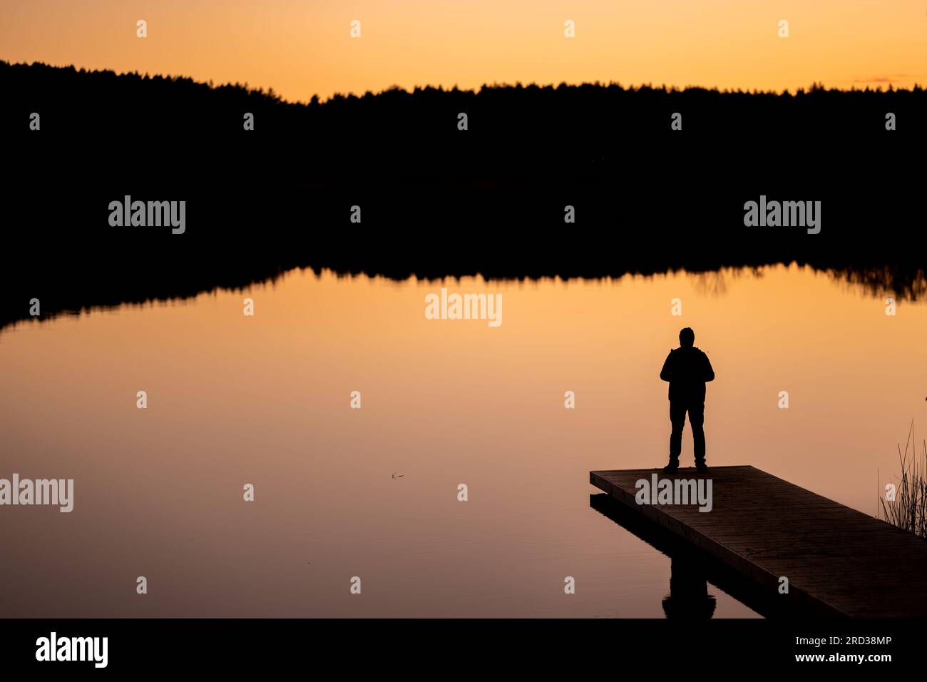 Silhouette of a hiker admiring beautiful waters of lake Gela on sunset ...