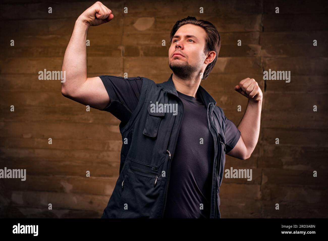 Young strong handsome man posing on wall background Stock Photo - Alamy