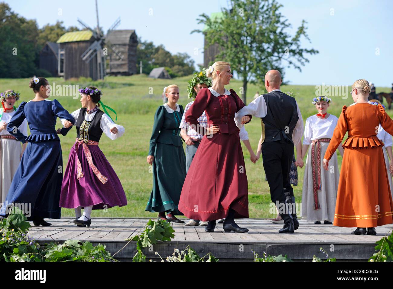 Men and women in national Latvian costumes dancing celebrating Jan Day ...