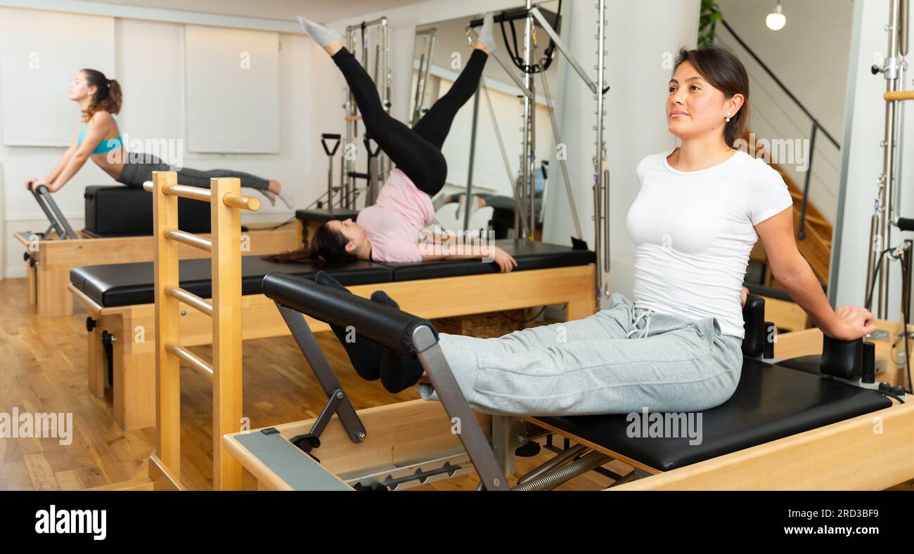 Women doing pilates exercises lying on pilates machines Stock Photo - Alamy