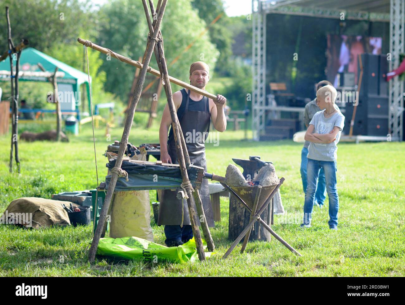 Young man blacksmith working in the traditional Latvian vintage outdoor ...