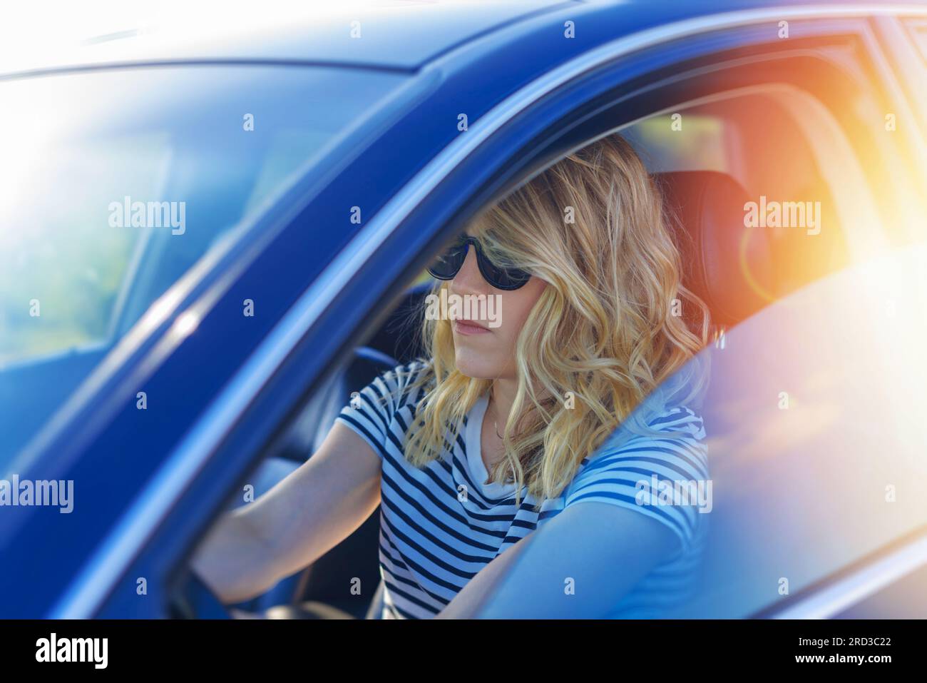 Beautiful blonde woman driving a car Stock Photo - Alamy
