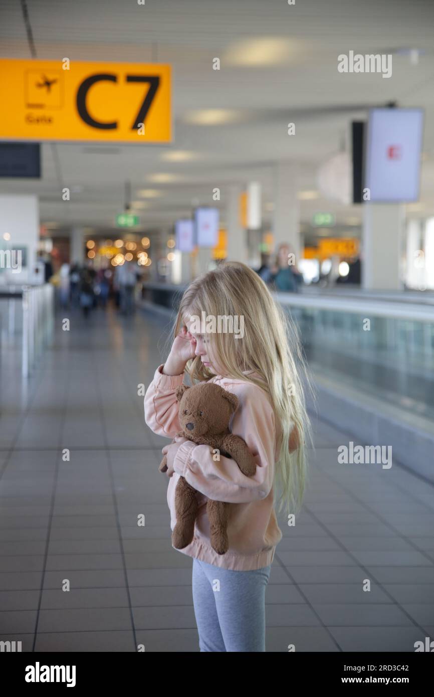 Child lost at the airport, can't find her parents. Upset little girl ...
