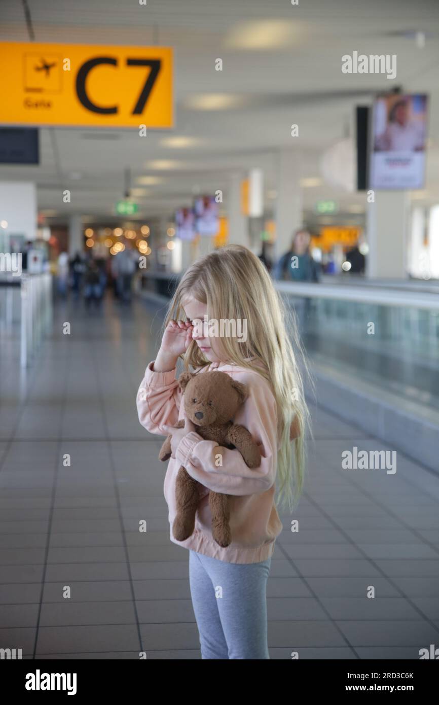 Child lost at the airport, can't find her parents. Upset little girl ...