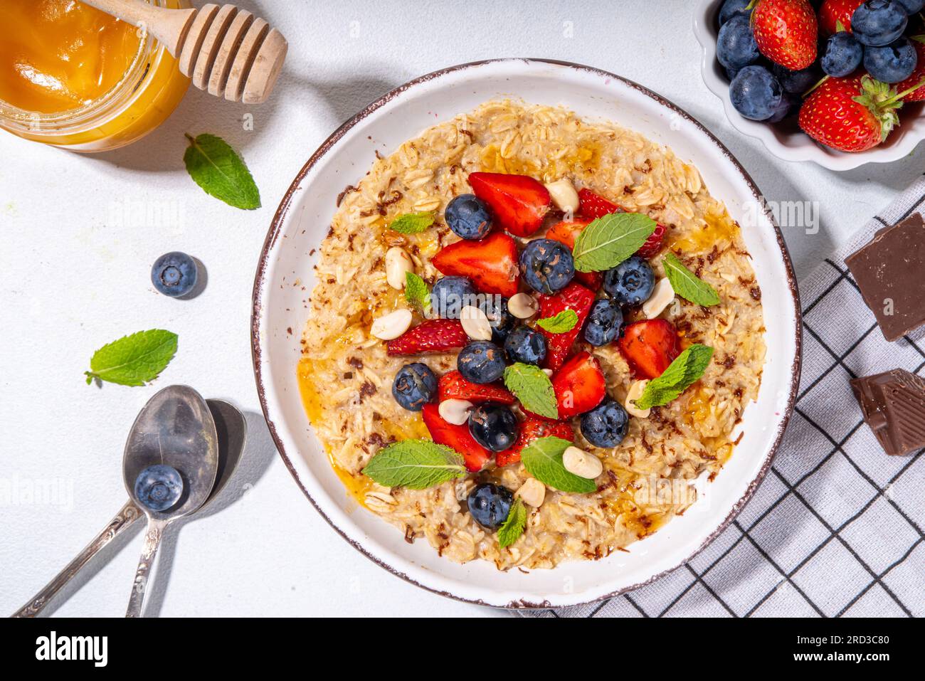 Summer breakfast oatmeal with strawberry, blueberry, nuts, chocolate ...