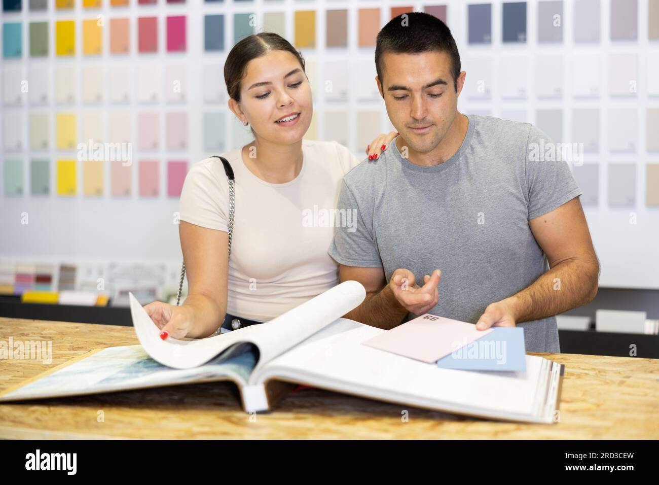 In store, couple buyer look at product catalog and choose color of ...