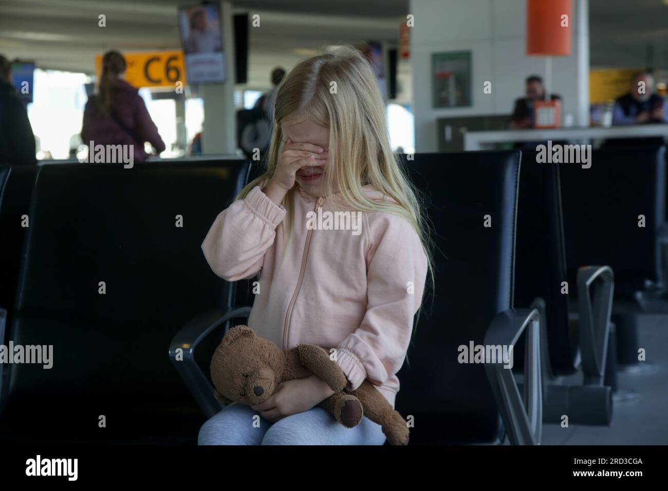 Child lost at the airport, can't find her parents. Upset little girl ...
