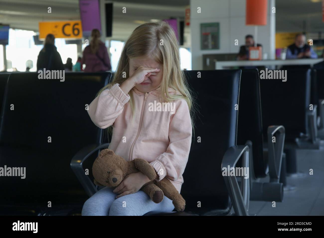 Child lost at the airport, can't find her parents. Upset little girl ...