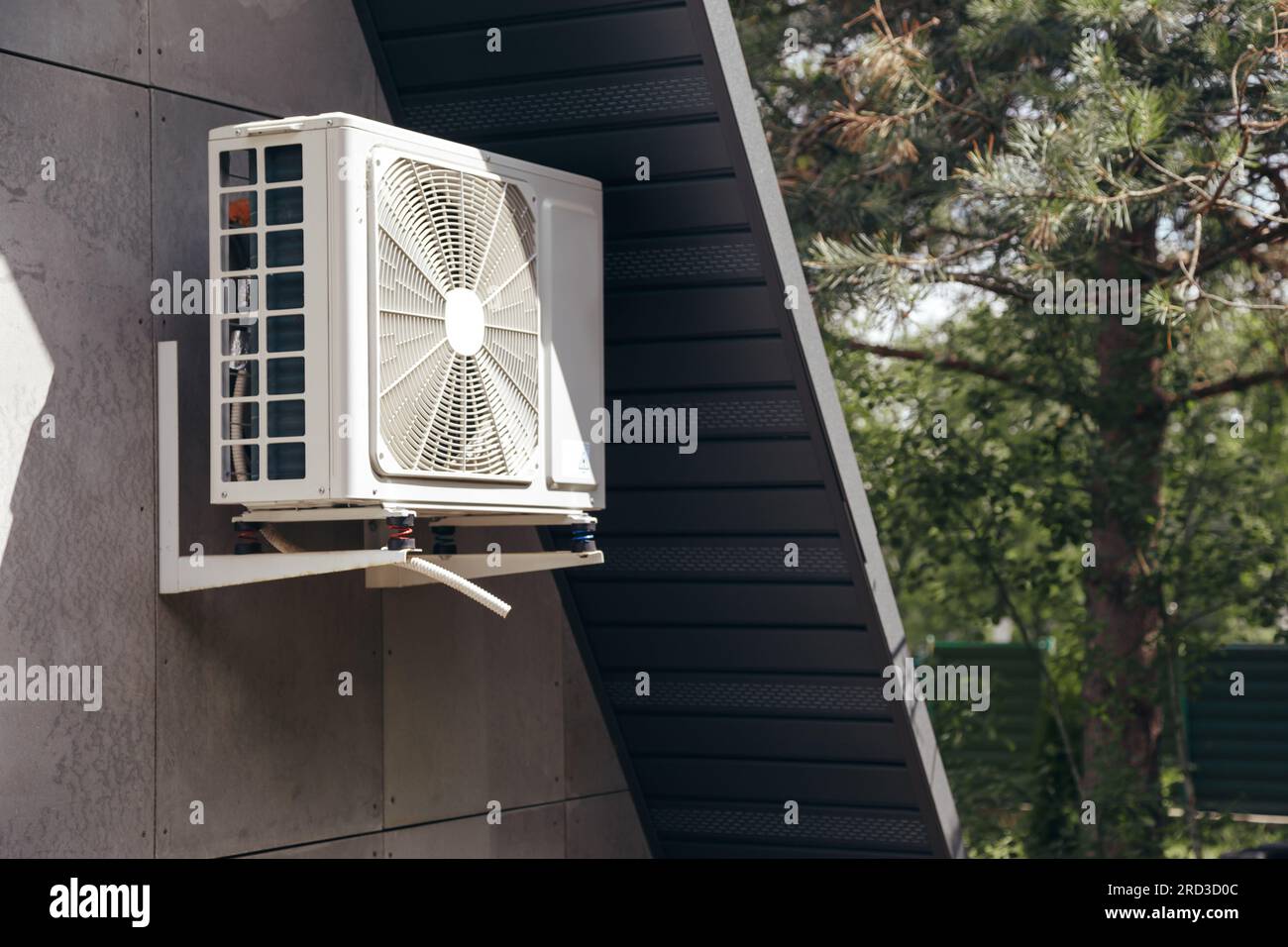 External unit of an air conditioner on facade of small wooden forest ...