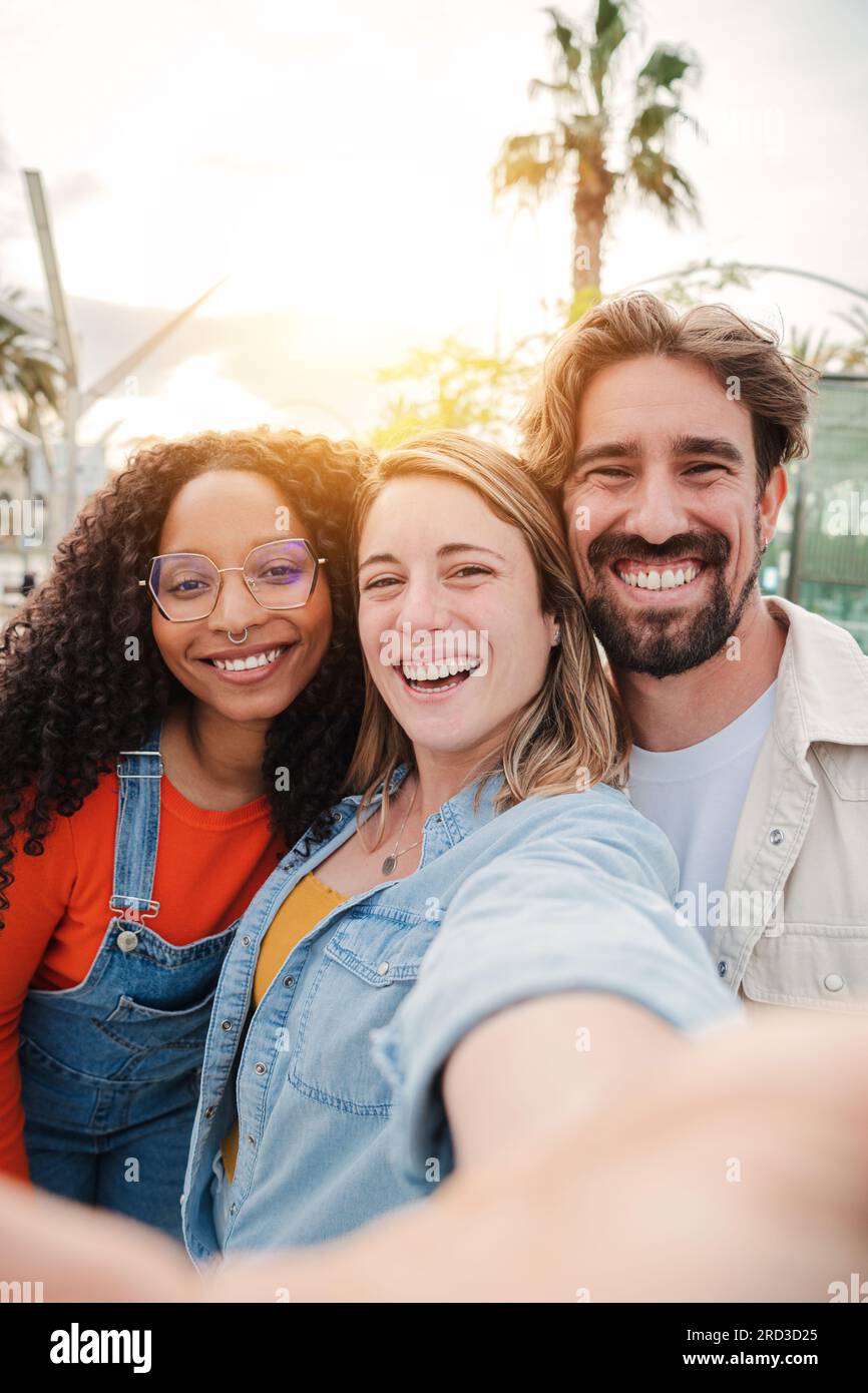 Vertical portrait. Group of young adult friends smiling taking a selfie ...