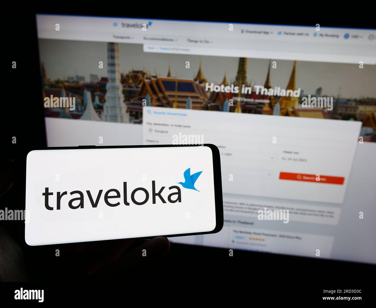 Person holding mobile phone with logo of Indonesian travel company ...