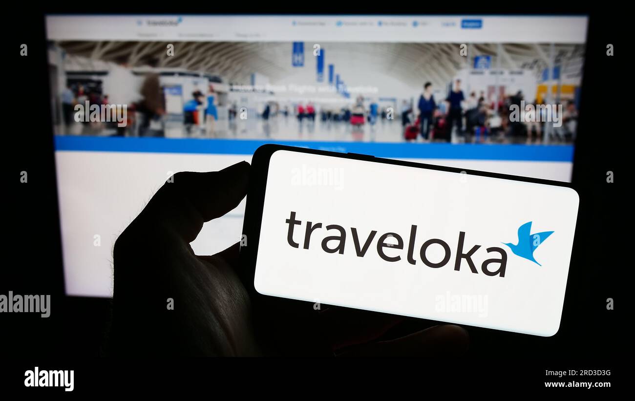 Person holding cellphone with logo of Indonesian travel company ...