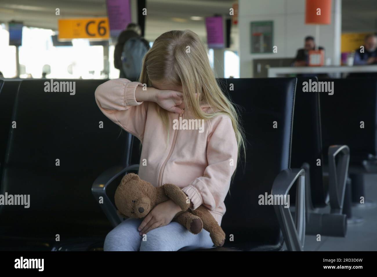 Child lost at the airport, can't find her parents. Upset little girl ...