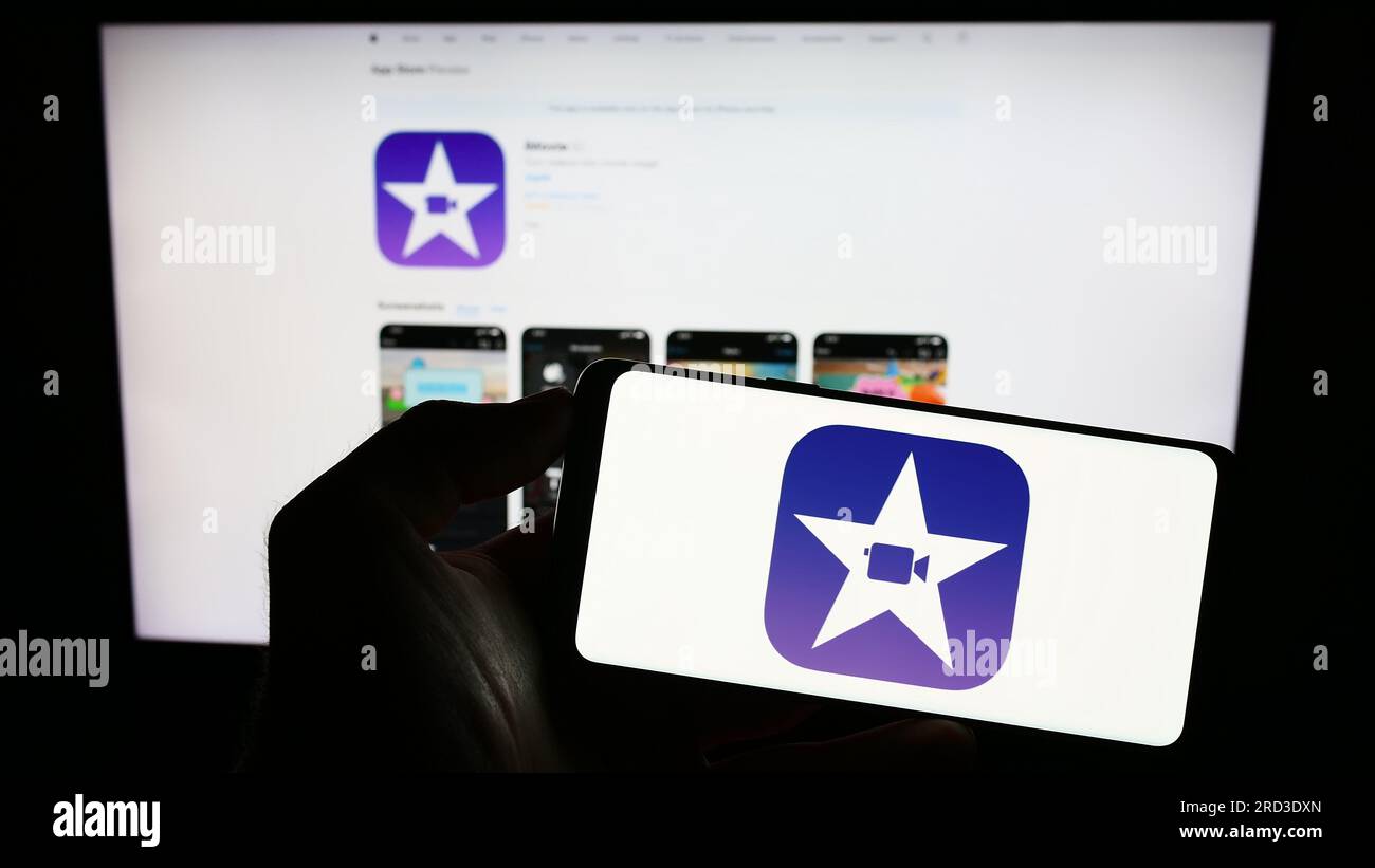 Person holding mobile phone with logo of video editing software iMovie ...