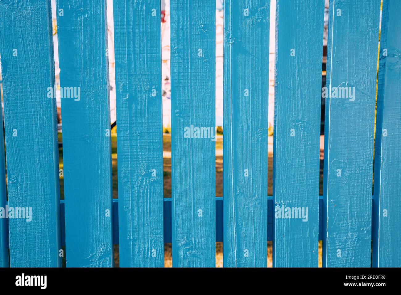 Decorative wooden painted in blue fence in the yard of the house with a ...