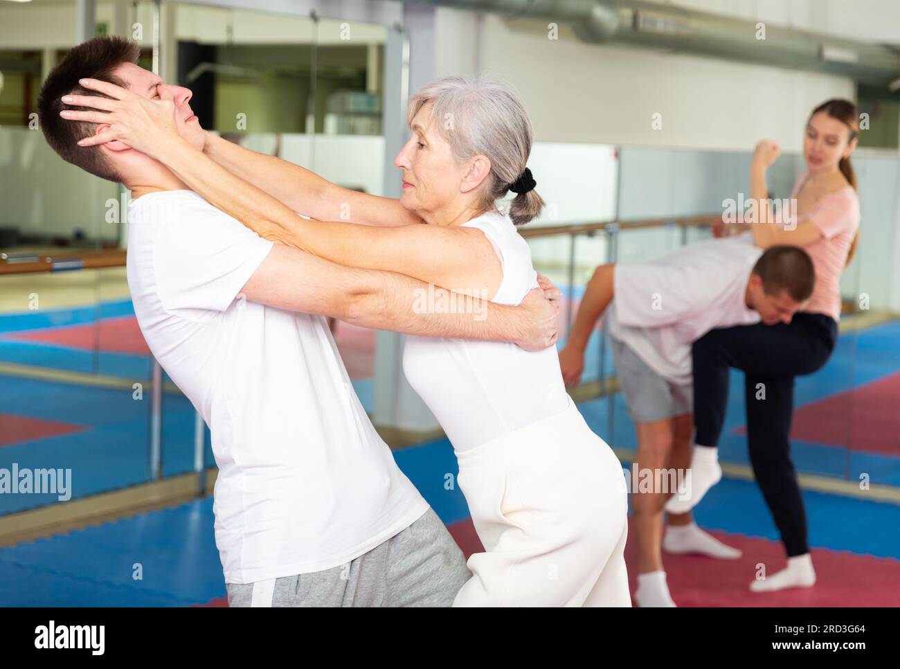 Senior woman performing eye-gouging move during self-defence training ...